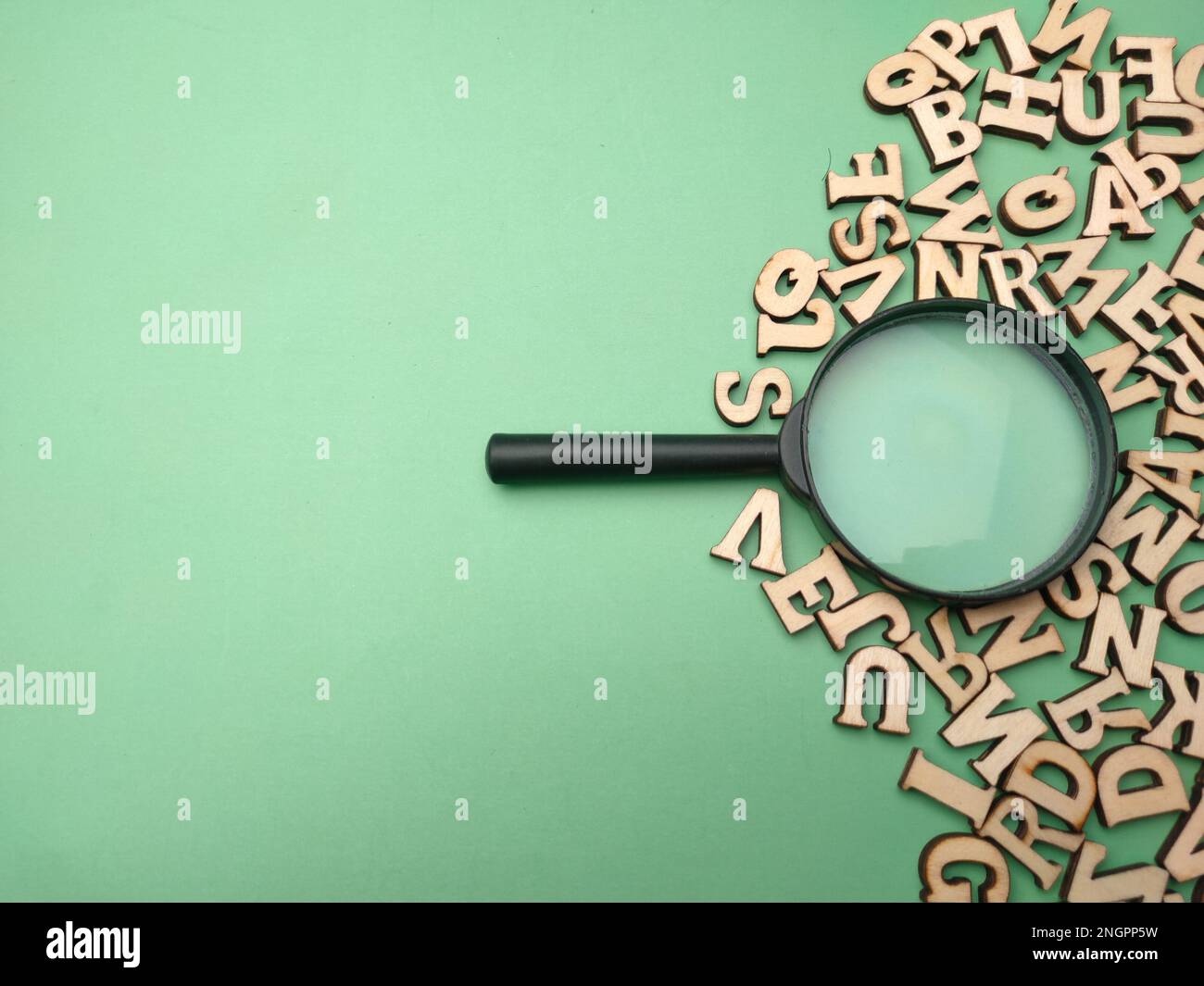 Wooden word and magnifying glass on a green background. Business ...