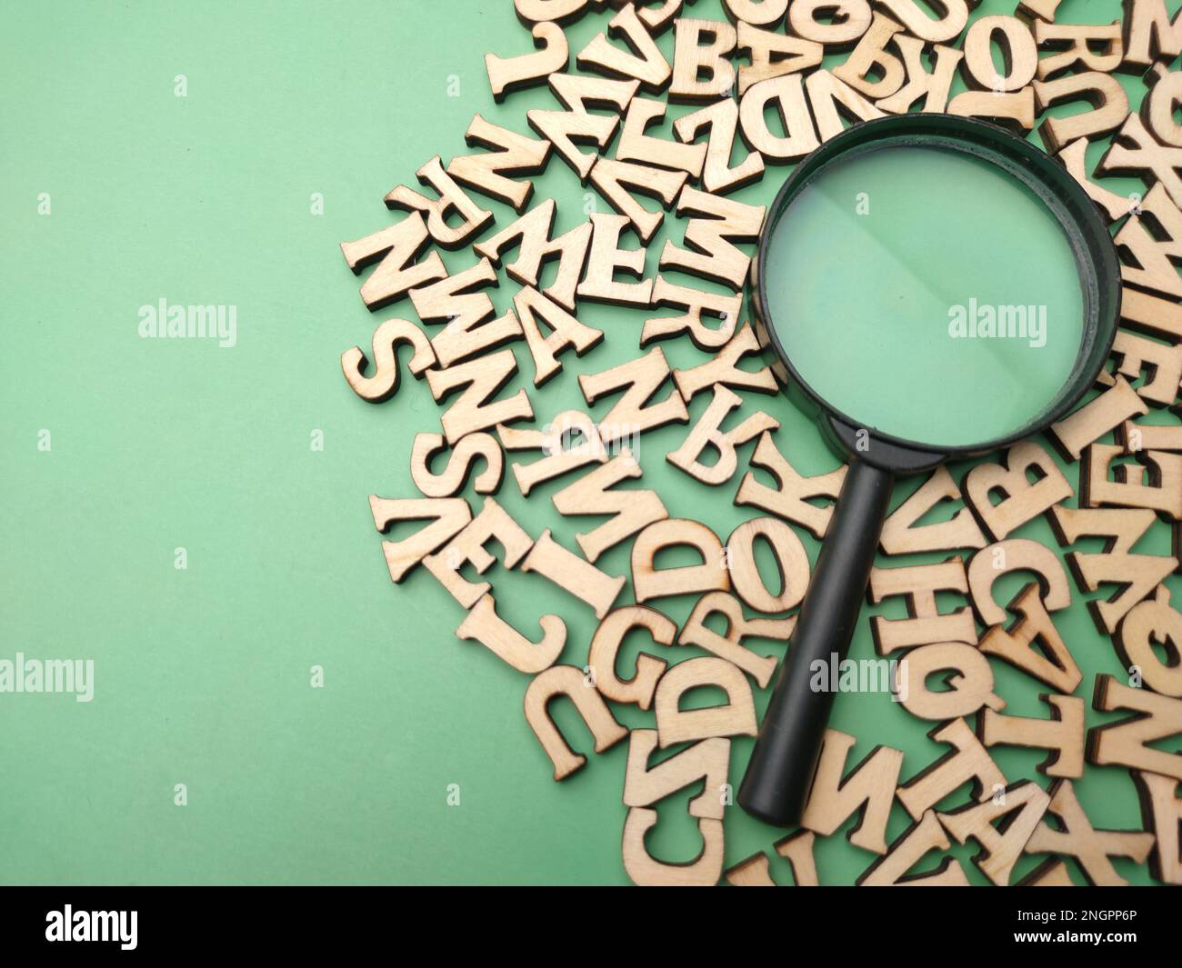 Wooden word and magnifying glass on a green background. Business ...