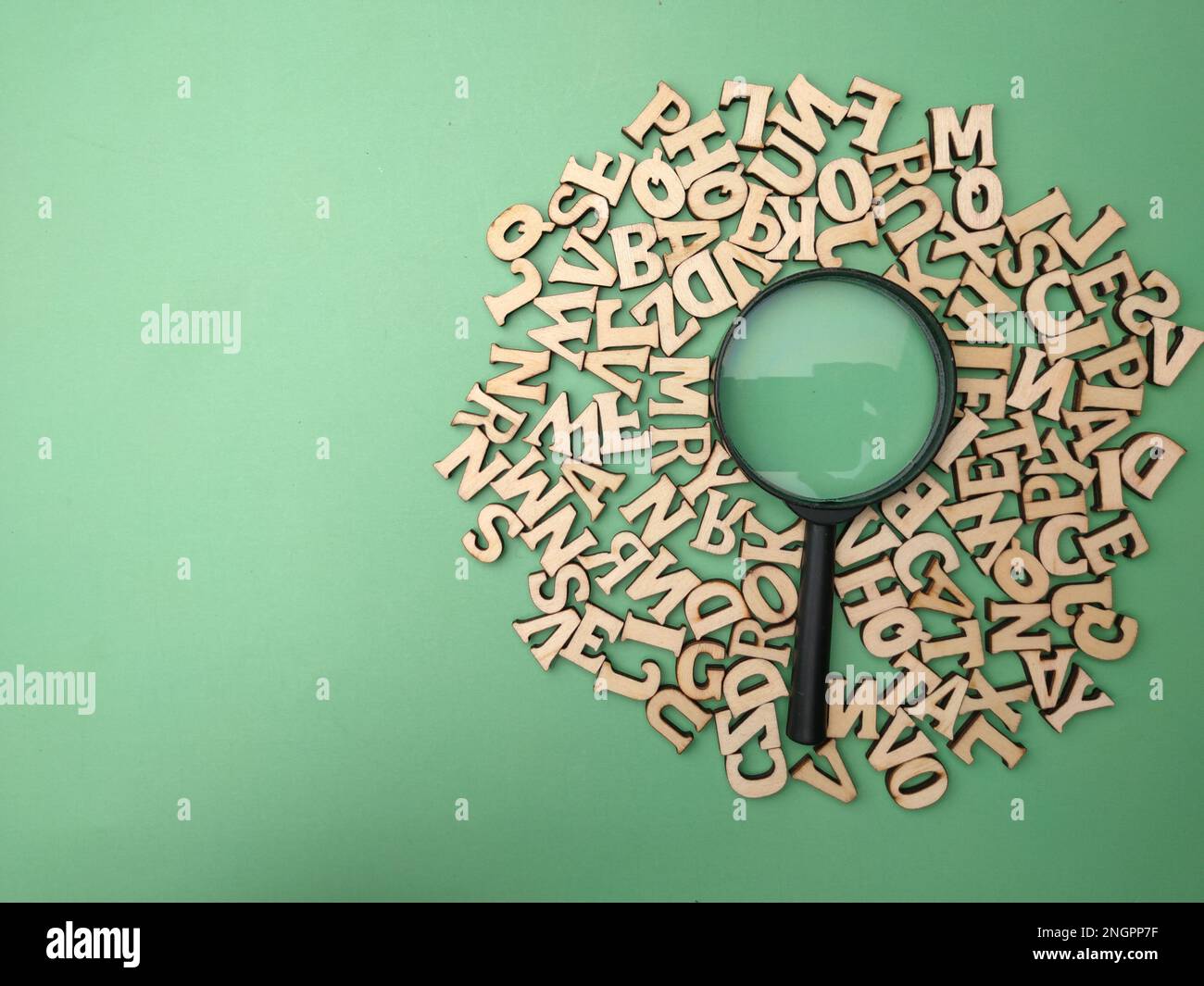 Wooden word and magnifying glass on a green background. Business ...