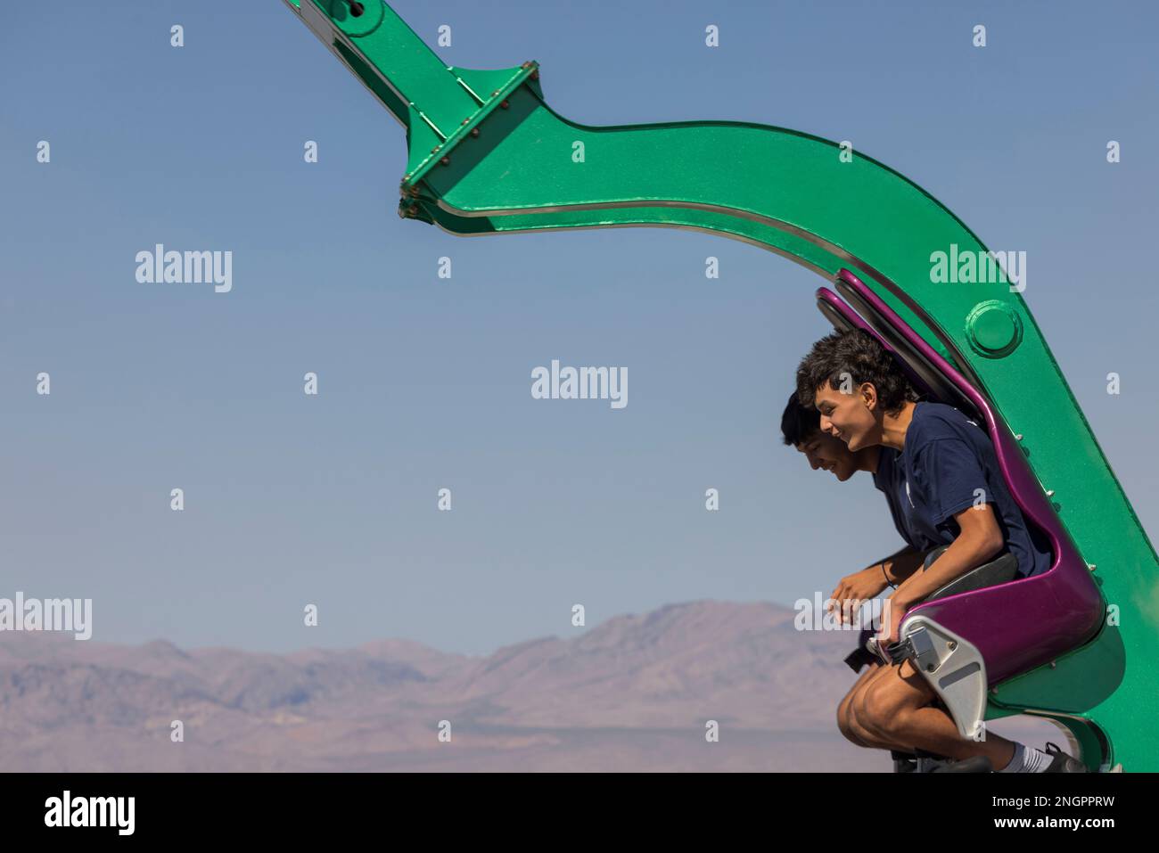 Close-up view of two guys riding carousel ride on observation tower of ...