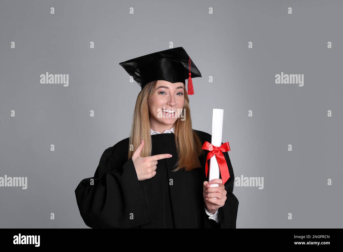 Happy student with diploma on grey background Stock Photo - Alamy