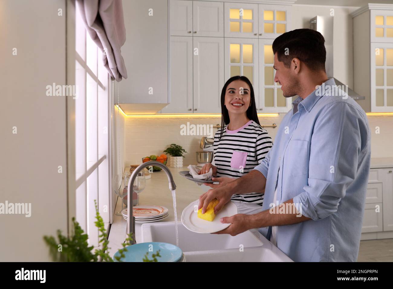 Happy lovely couple washing dishes in kitchen Stock Photo - Alamy