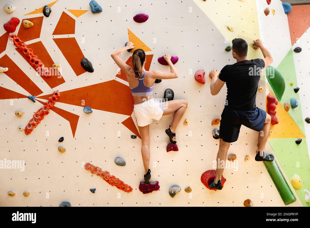 Athletic man and woman climbing wall in gym, back view Stock Photo - Alamy