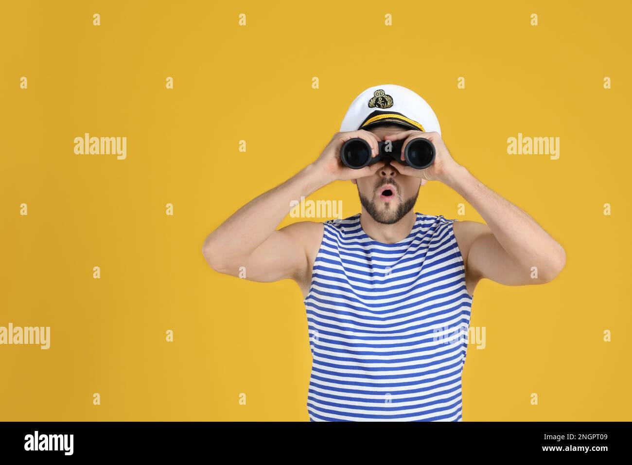 Sailor looking through binoculars on yellow background, space for text ...