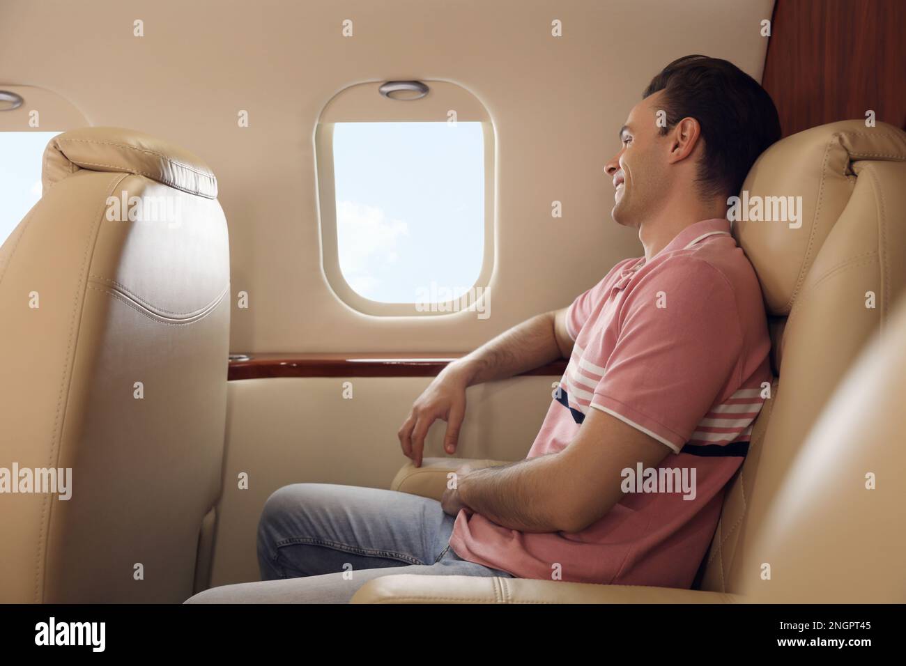 Young man looking out window in airplane during flight Stock Photo - Alamy