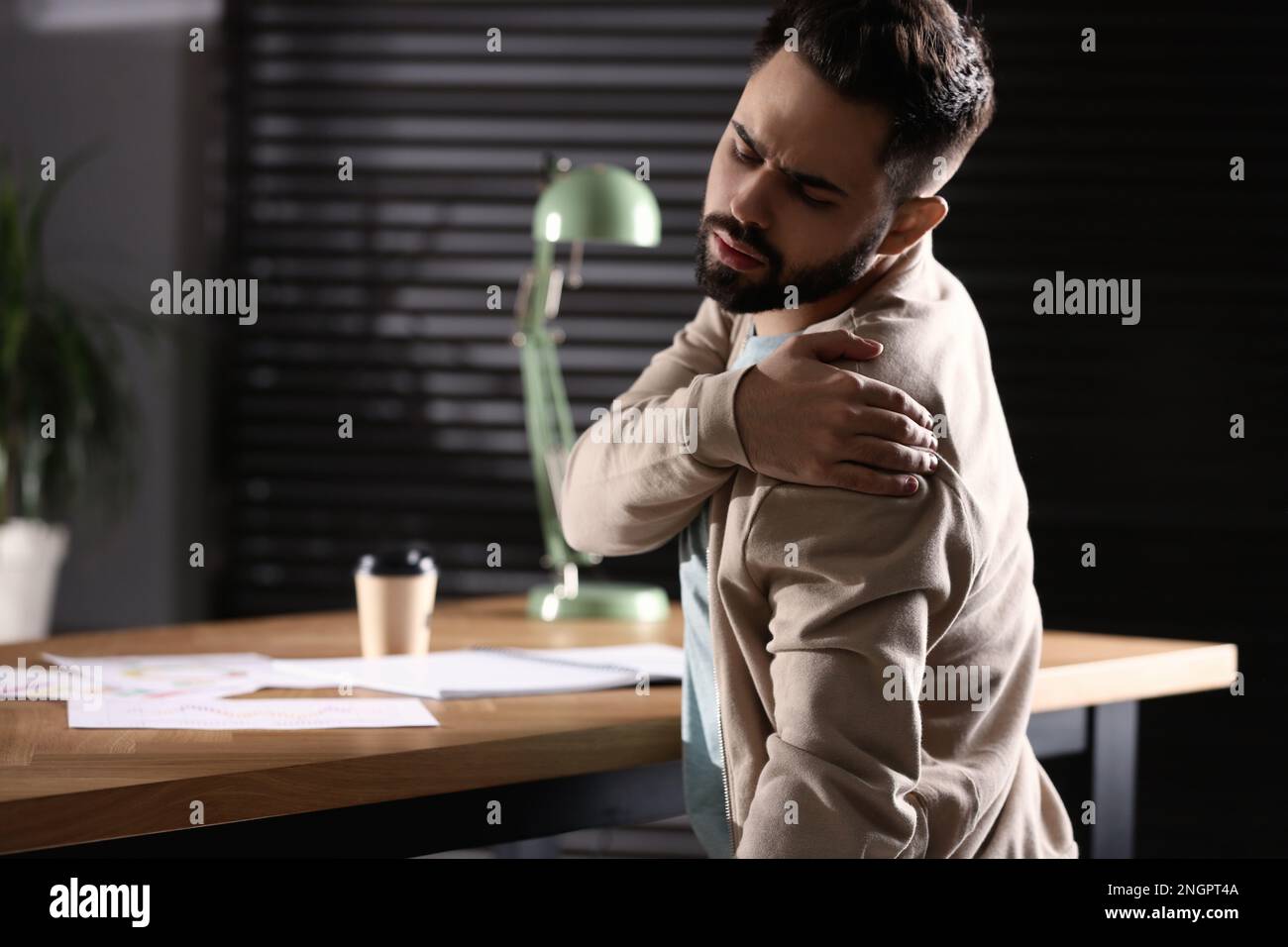 Man suffering from shoulder pain in office. Bad posture problem Stock ...