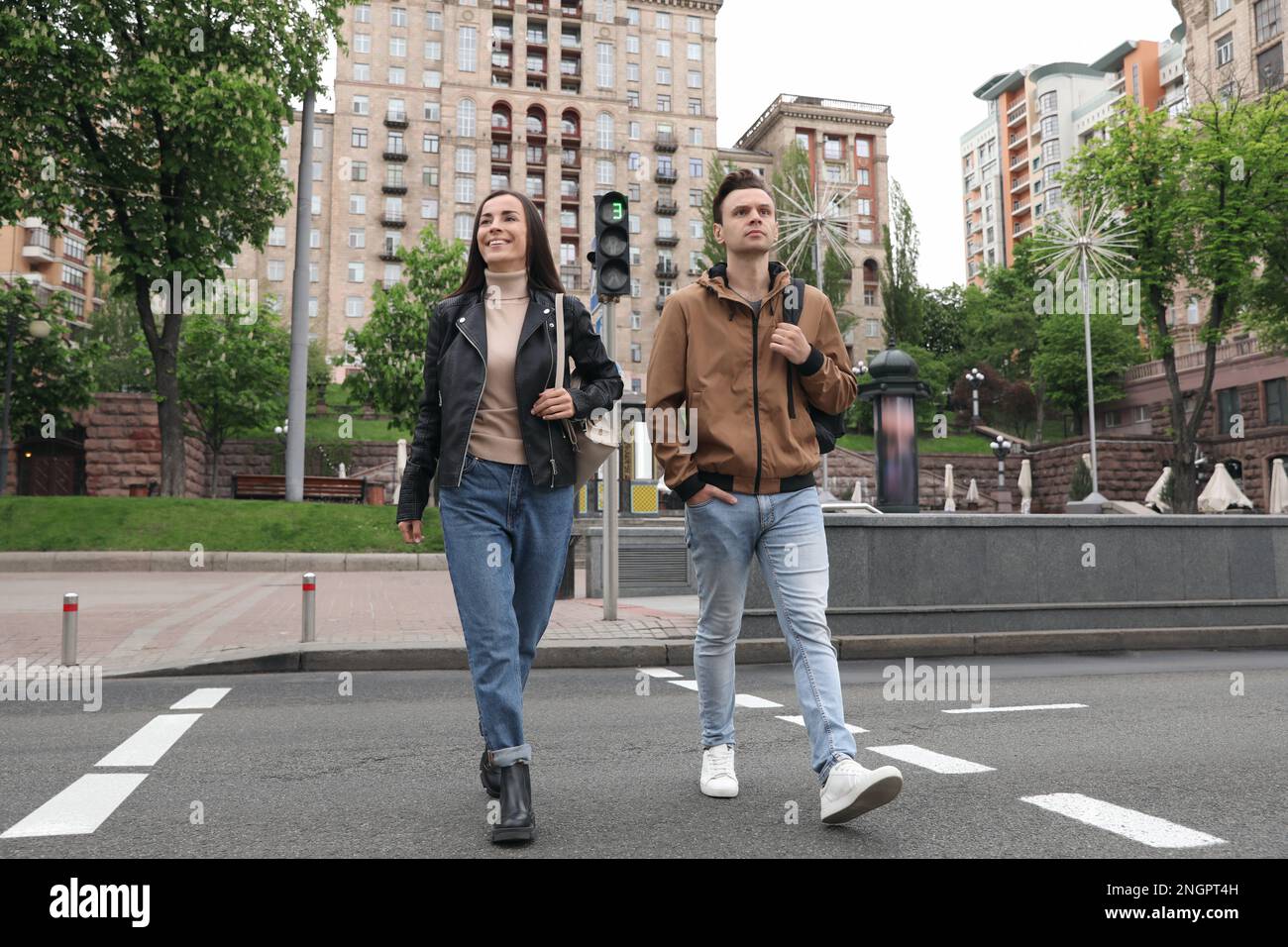 Young people crossing street at traffic lights Stock Photo - Alamy