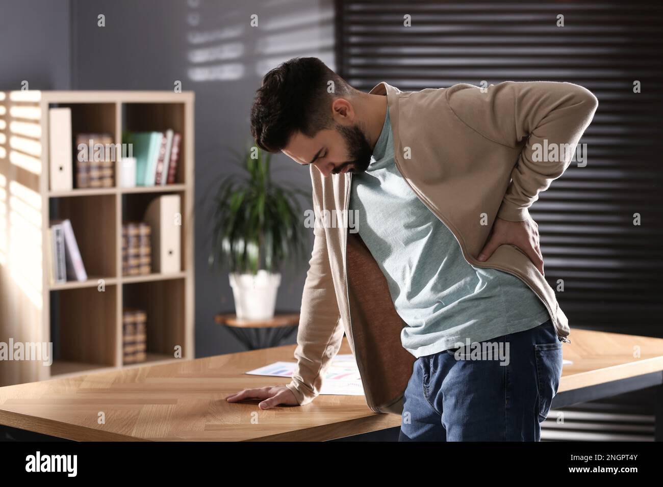 Man suffering from back pain in office. Bad posture problem Stock Photo ...