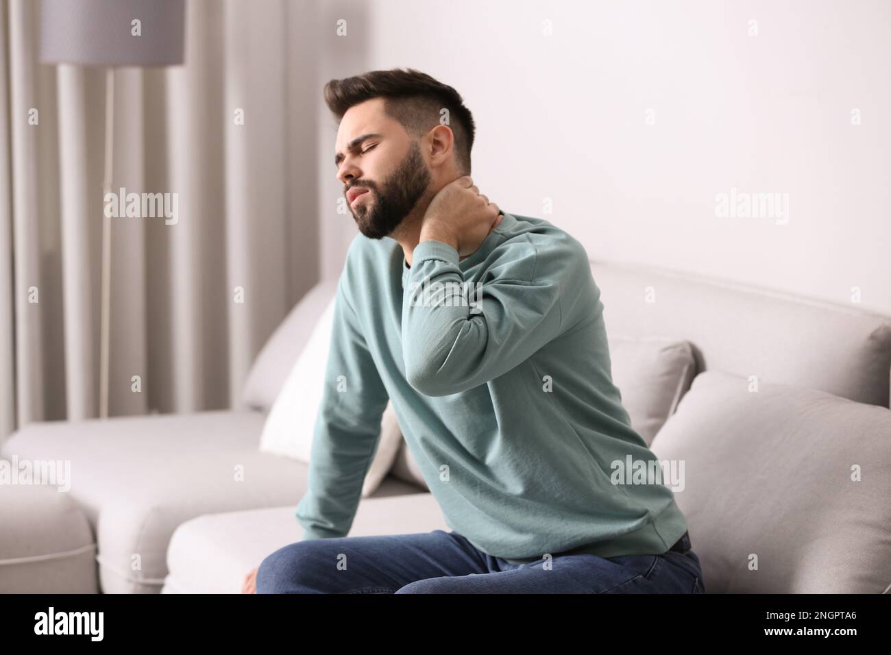 Man suffering from back pain at home. Bad posture problem Stock Photo ...