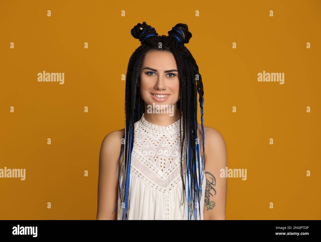 Beautiful young woman with nose piercing and dreadlocks on yellow ...