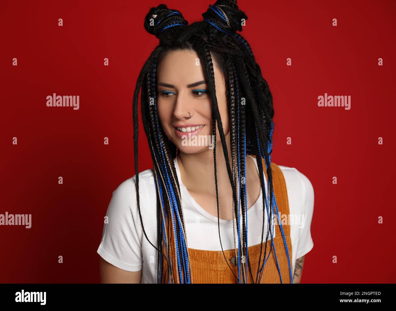 Beautiful young woman with nose piercing and dreadlocks on red ...