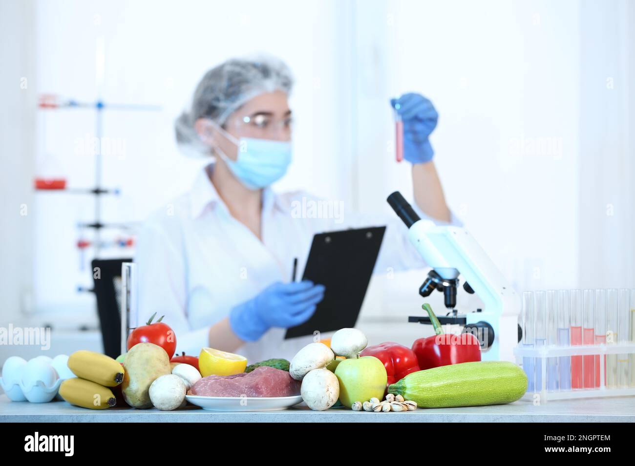 Fresh vegetables, fruits, meat on table and scientist proceeding ...
