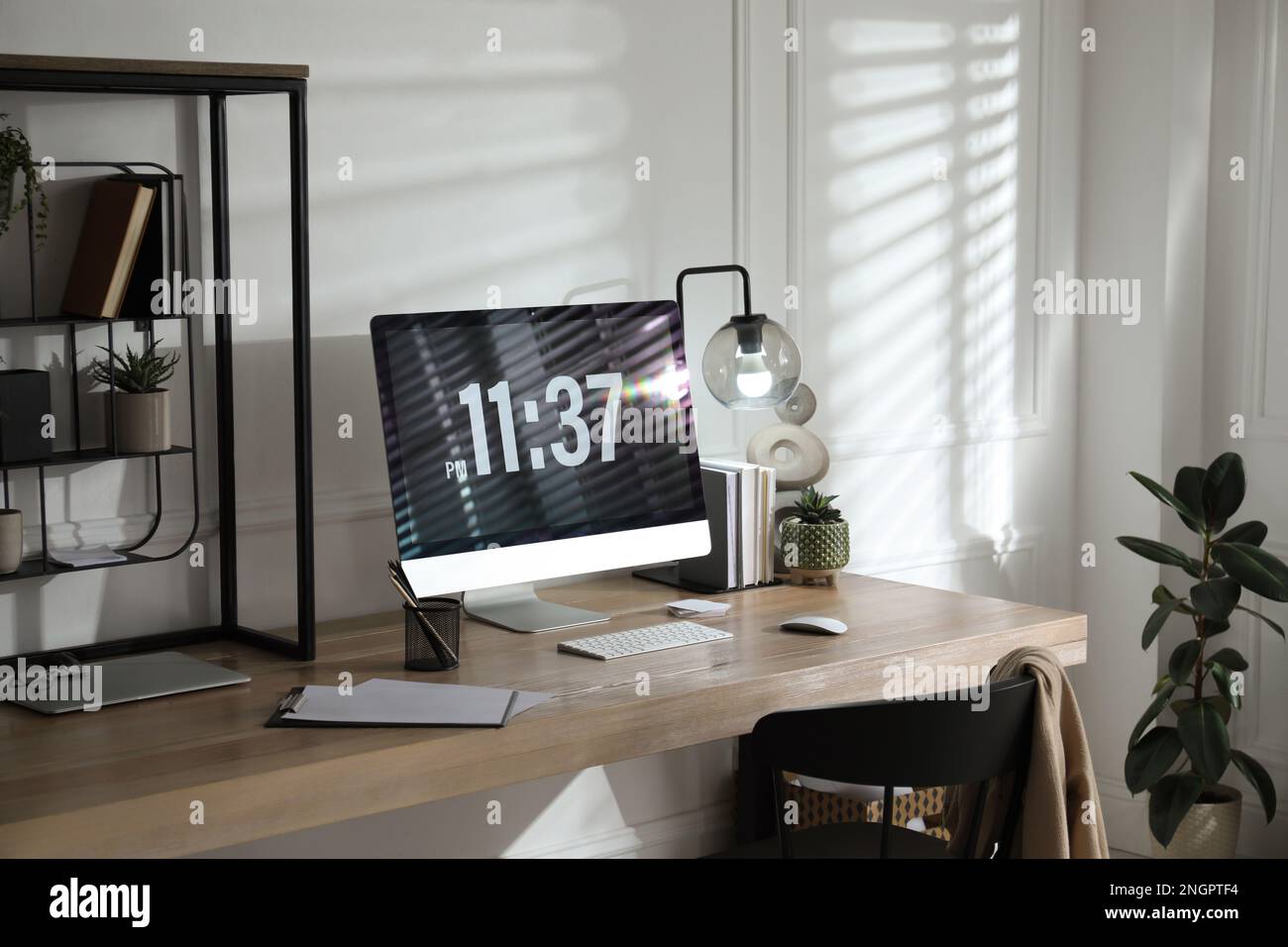 Modern computer and laptop on wooden desk in room. Interior design ...