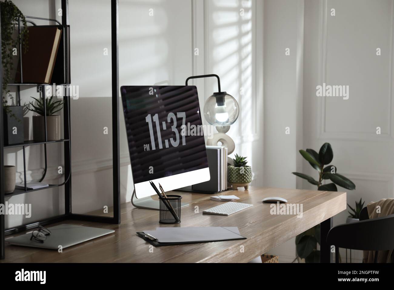 Modern computer and laptop on wooden desk in room. Interior design ...