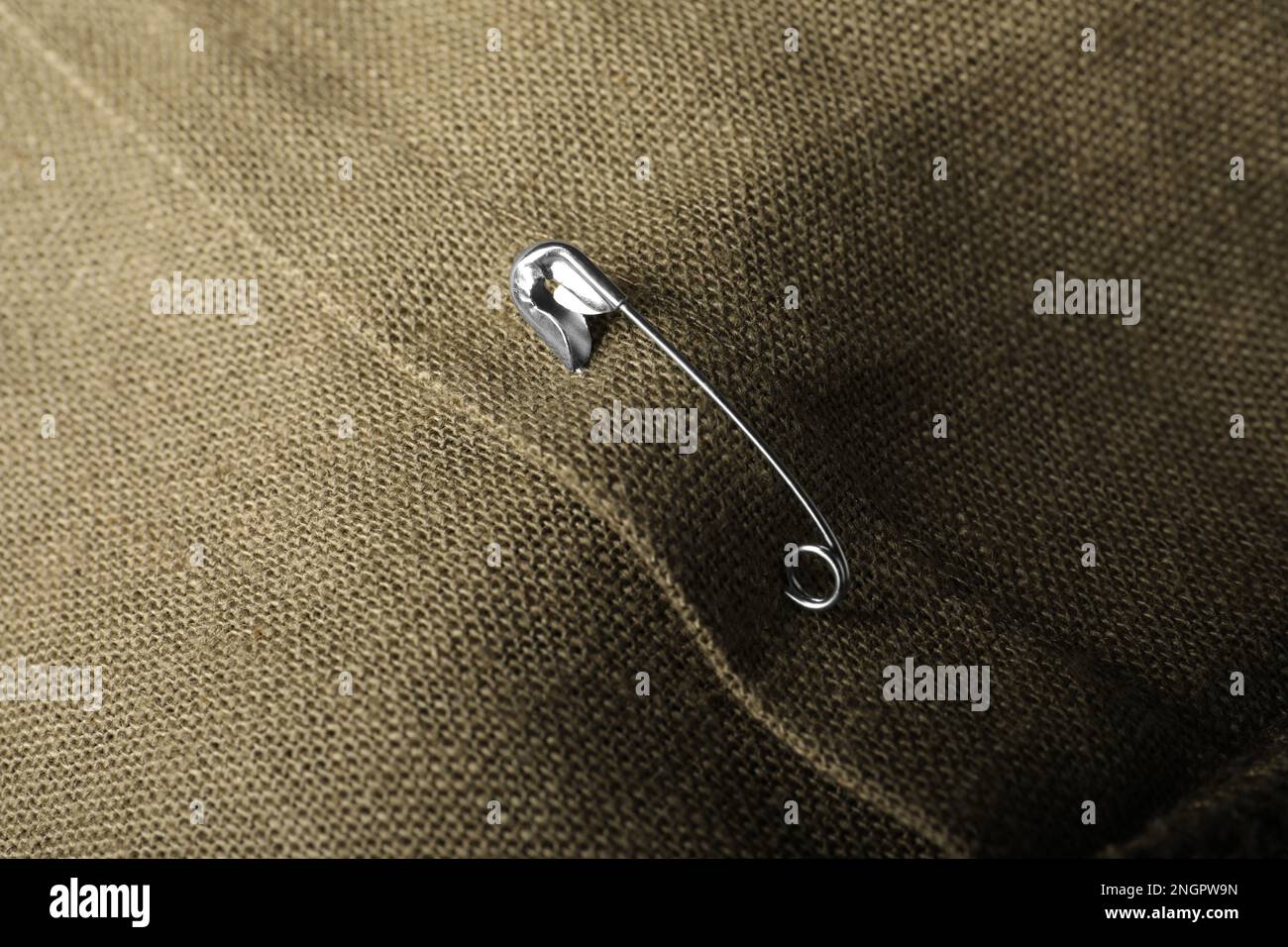 Metal safety pin on fabric, closeup view Stock Photo - Alamy