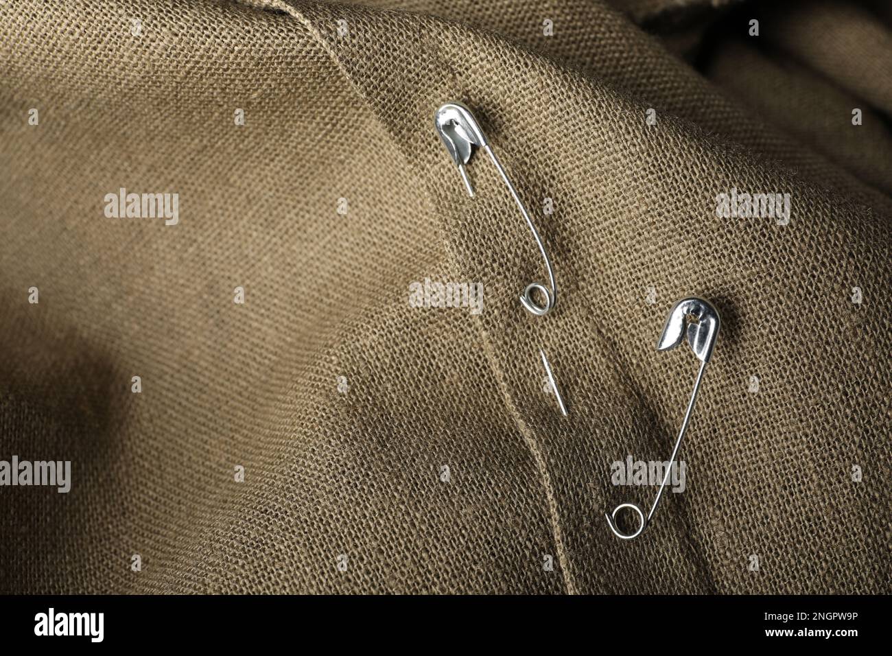 Metal safety pins on fabric, closeup view Stock Photo - Alamy