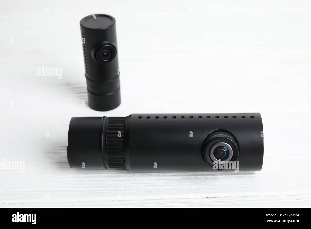 Black modern car cameras on white wooden table, closeup Stock Photo - Alamy