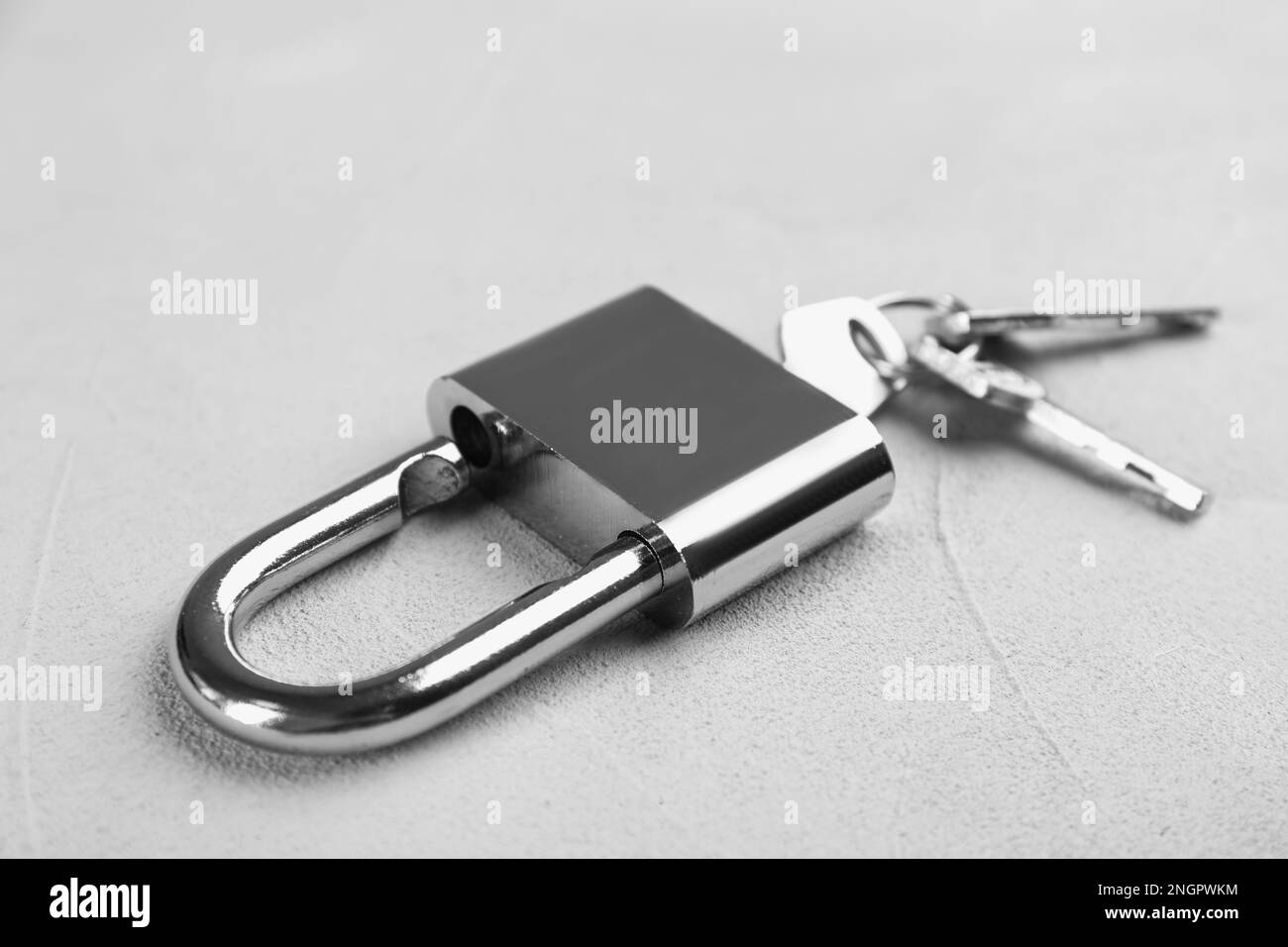 Modern padlock with keys on light table, closeup Stock Photo - Alamy