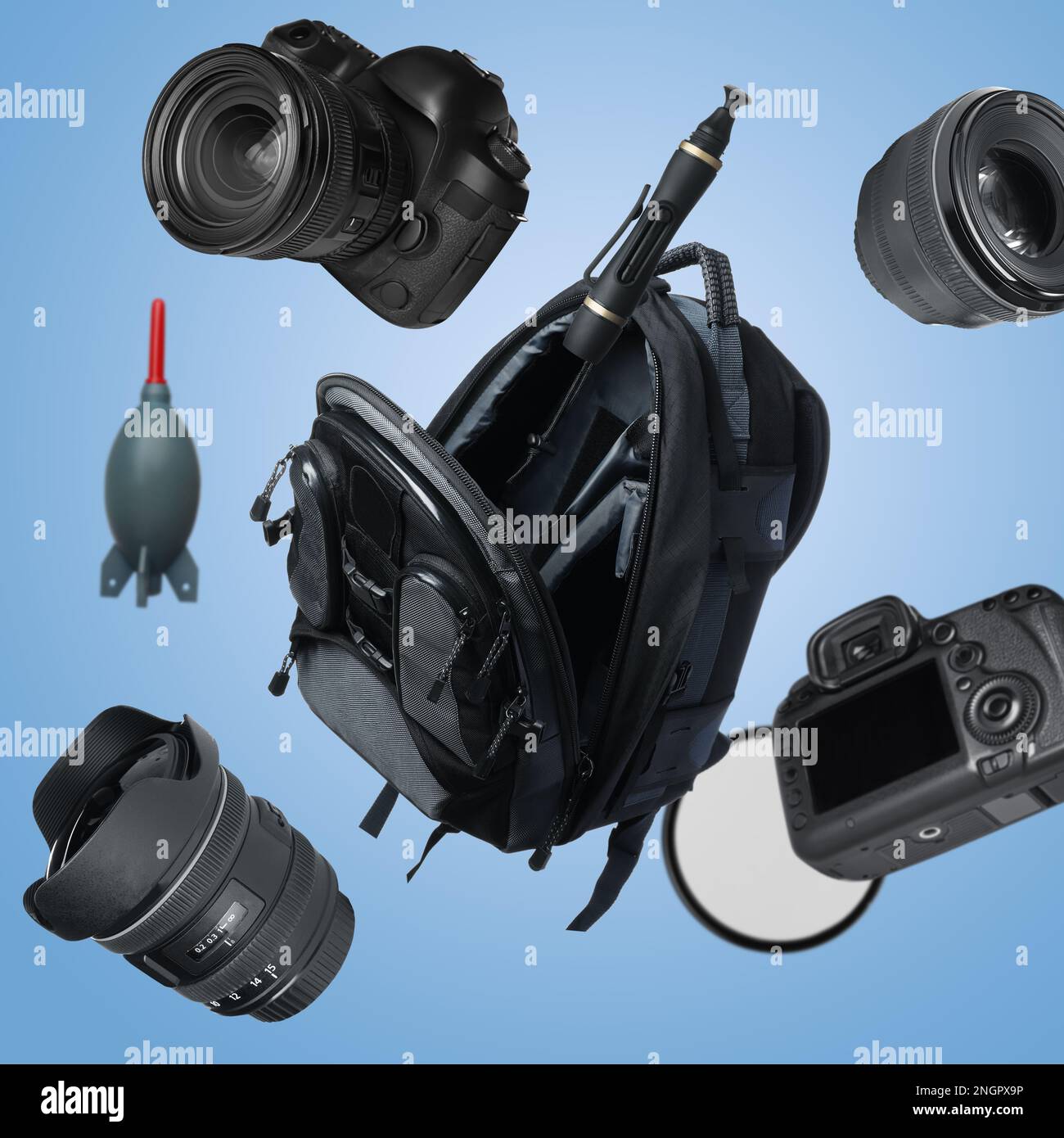 Different professional photography equipment falling on light blue ...