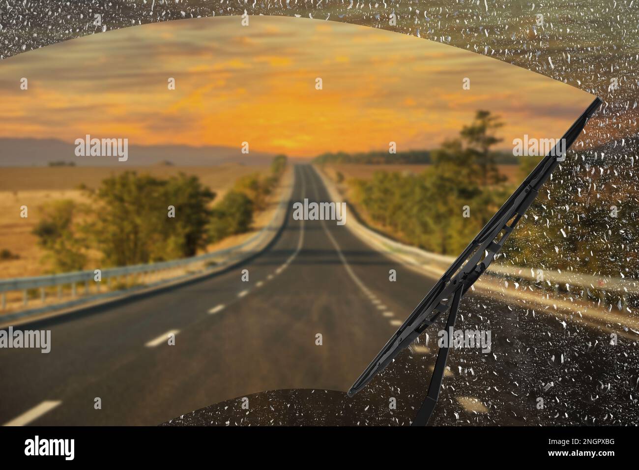 Car windshield wiper cleaning water drops from glass while driving ...