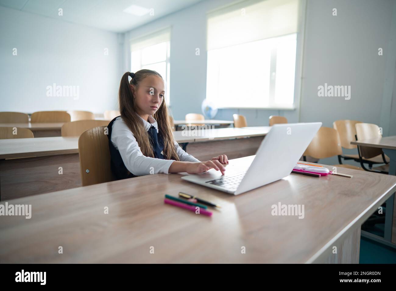 Caucasian girl studying on a laptop in a classroom Stock Photo - Alamy