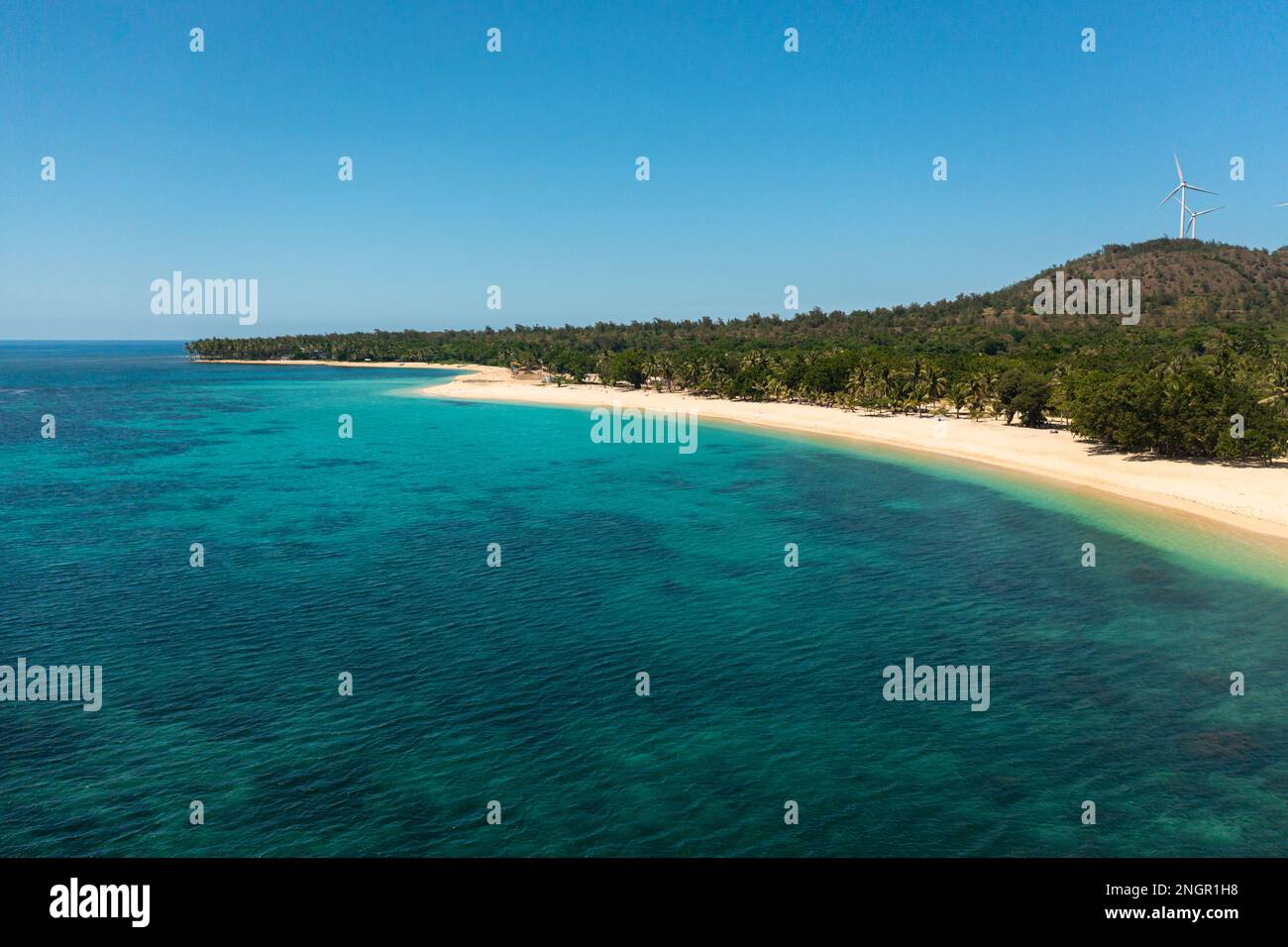 A tropical beach with palm trees and a blue ocean. Pagudpud, Ilocos ...