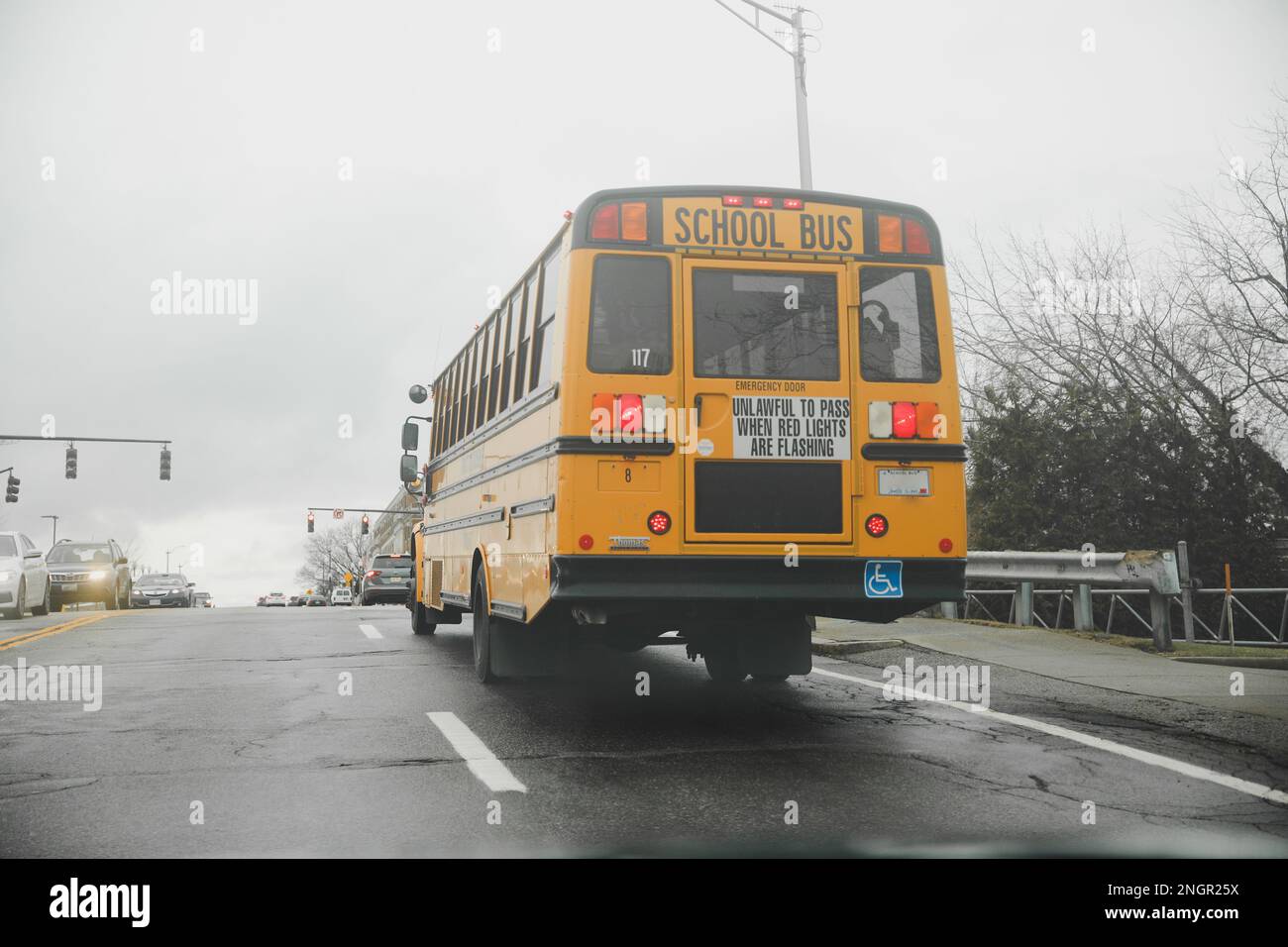 yellow school bus in public with stop sign showing Stock Photo - Alamy