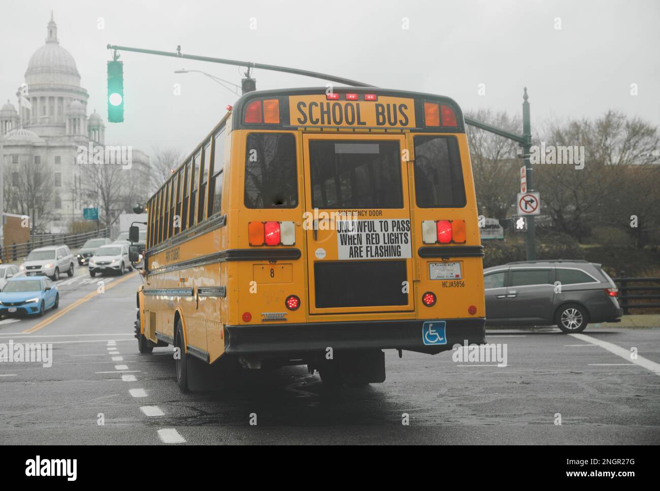 yellow school bus in public with stop sign showing Stock Photo - Alamy