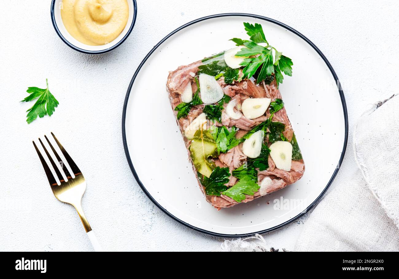 Aspic meat, cold boiled beef in spiced jelly broth on plate, dijon ...