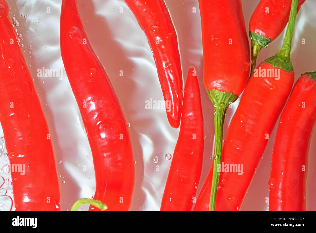 Close-up of fresh slices chilli peppers on white background. Red chilli ...
