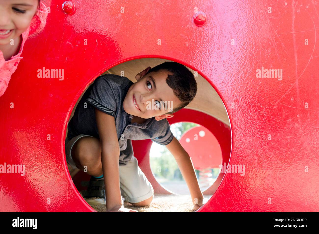 Two kids having fun playing together on a playground in a park Stock ...