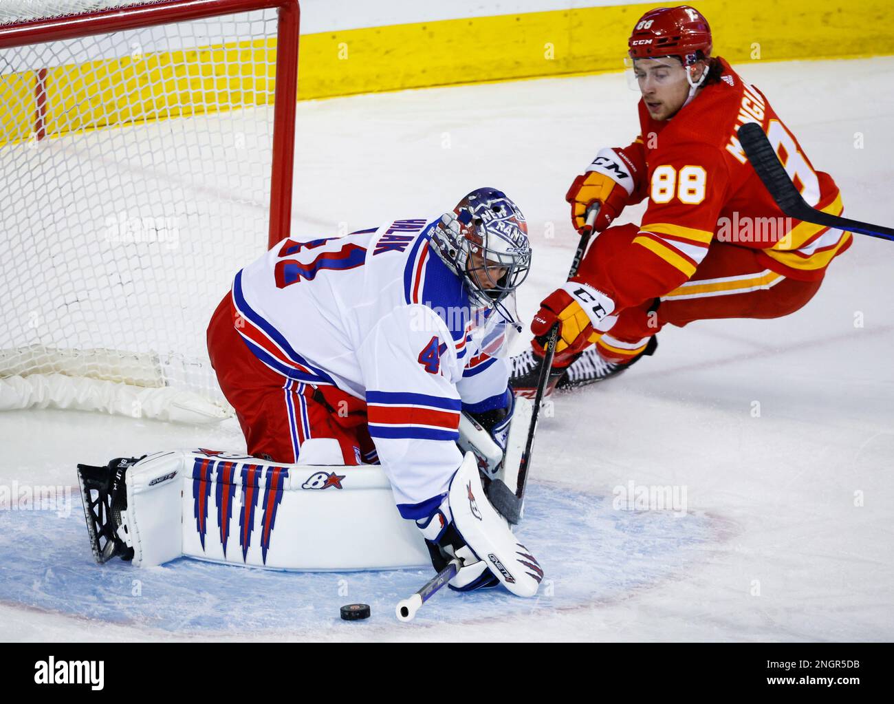 New York Rangers goalie Jaroslav Halak, left, blocks a shot by Calgary ...
