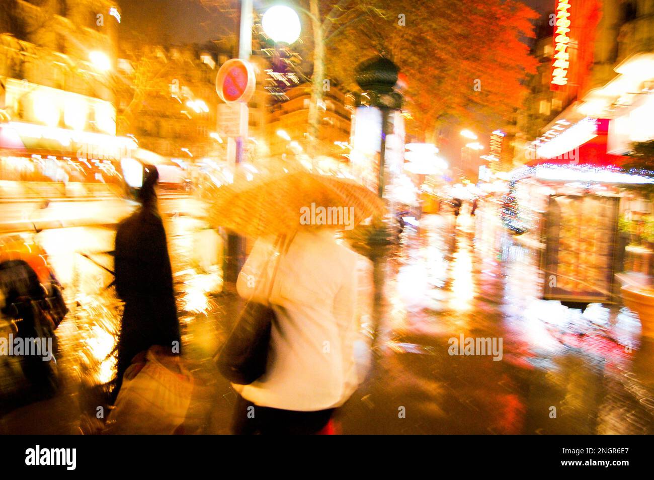 Strollers on a rainy night amid the lights of Boulevard St. Germain ...