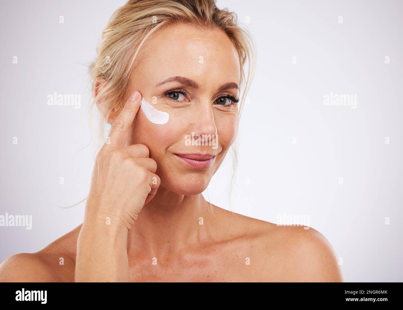 Portrait, face cream and skincare for mature woman in studio for ...