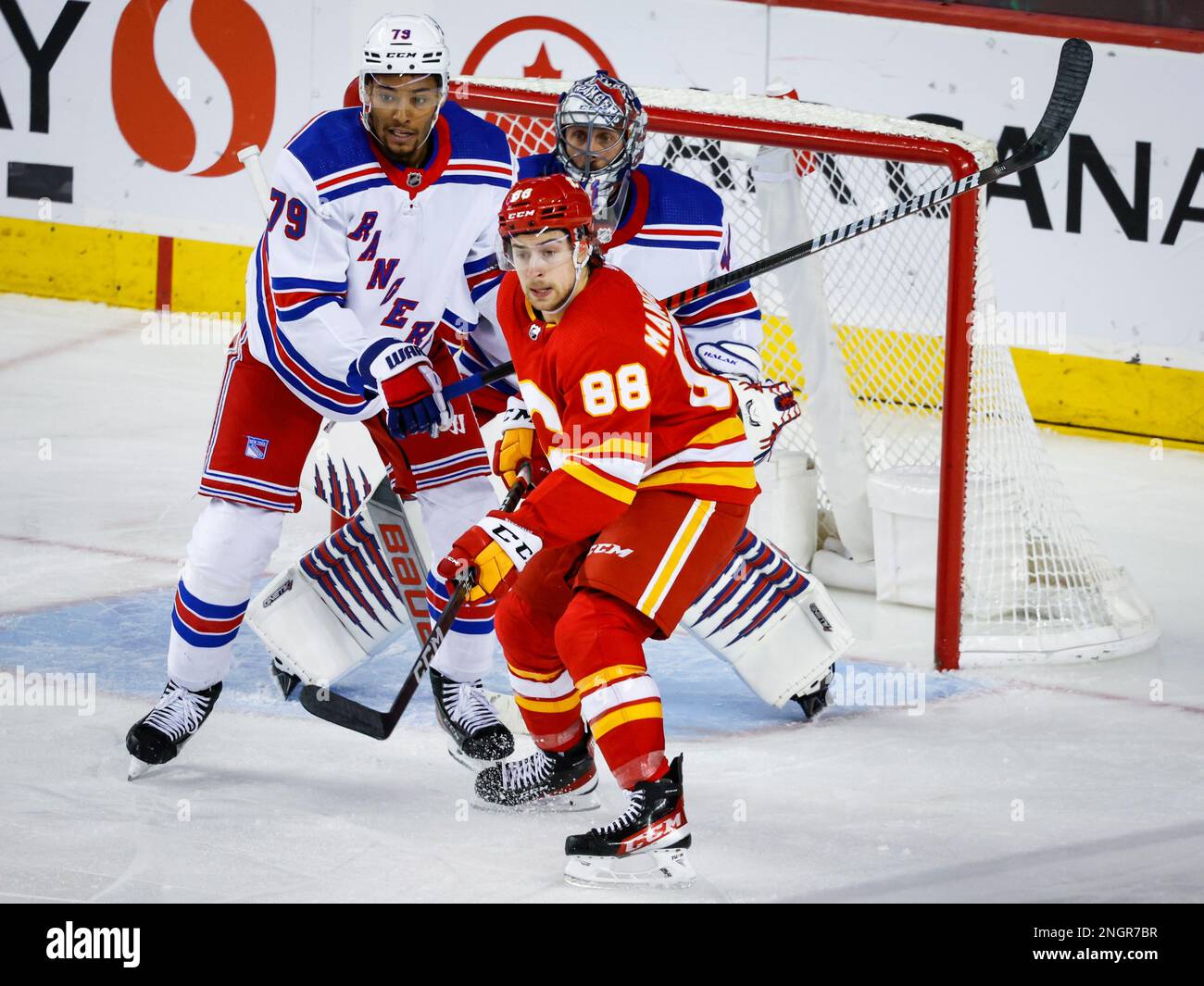 New York Rangers defenseman K'Andre Miller, left, pushes Calgary Flames ...