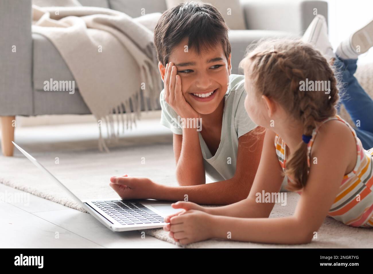 Little boy and girl watching cartoons on laptop at home Stock Photo - Alamy