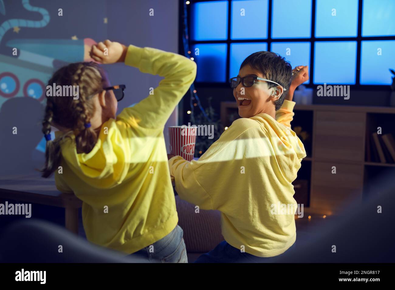 Little children in 3D glasses with popcorn watching cartoons on ...