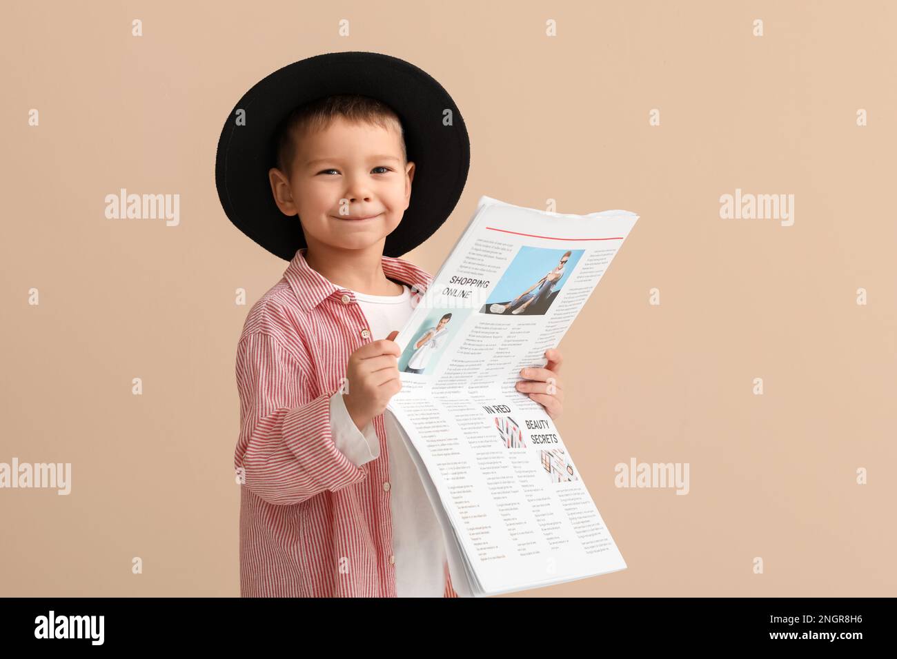 Cute little stylist with newspaper on beige background Stock Photo - Alamy