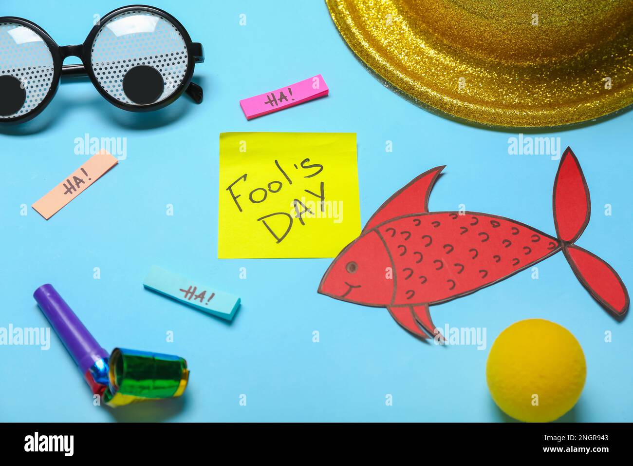 Sticky note with text FOOL'S DAY and party decor on color background ...