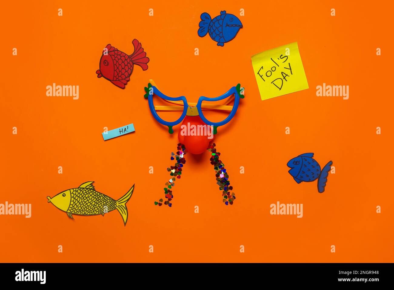 Composition with party decor and paper fishes on color background ...
