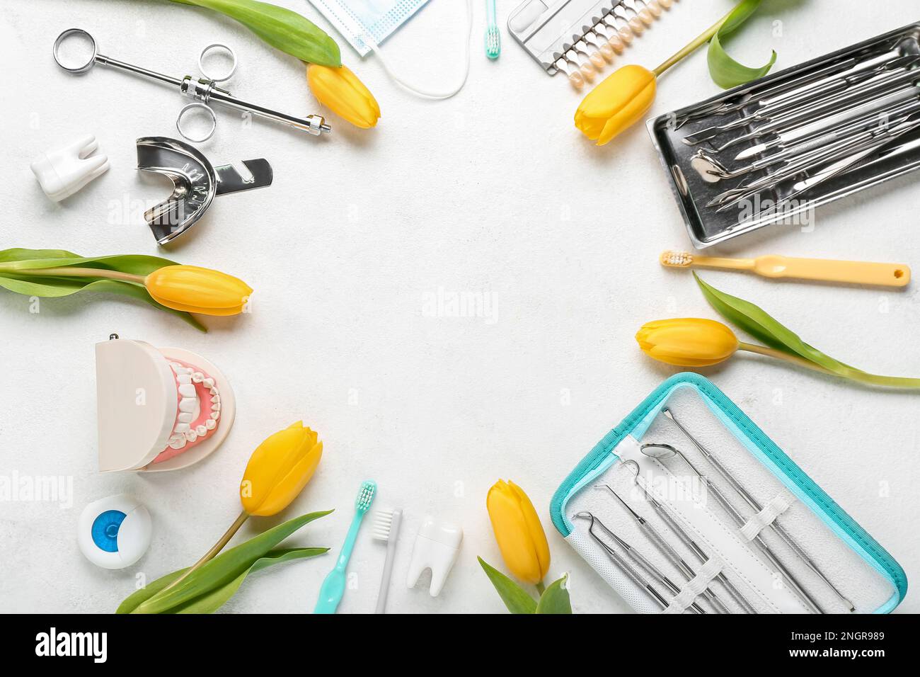 Frame made of dentist's tools and tulips on white background. Hello ...