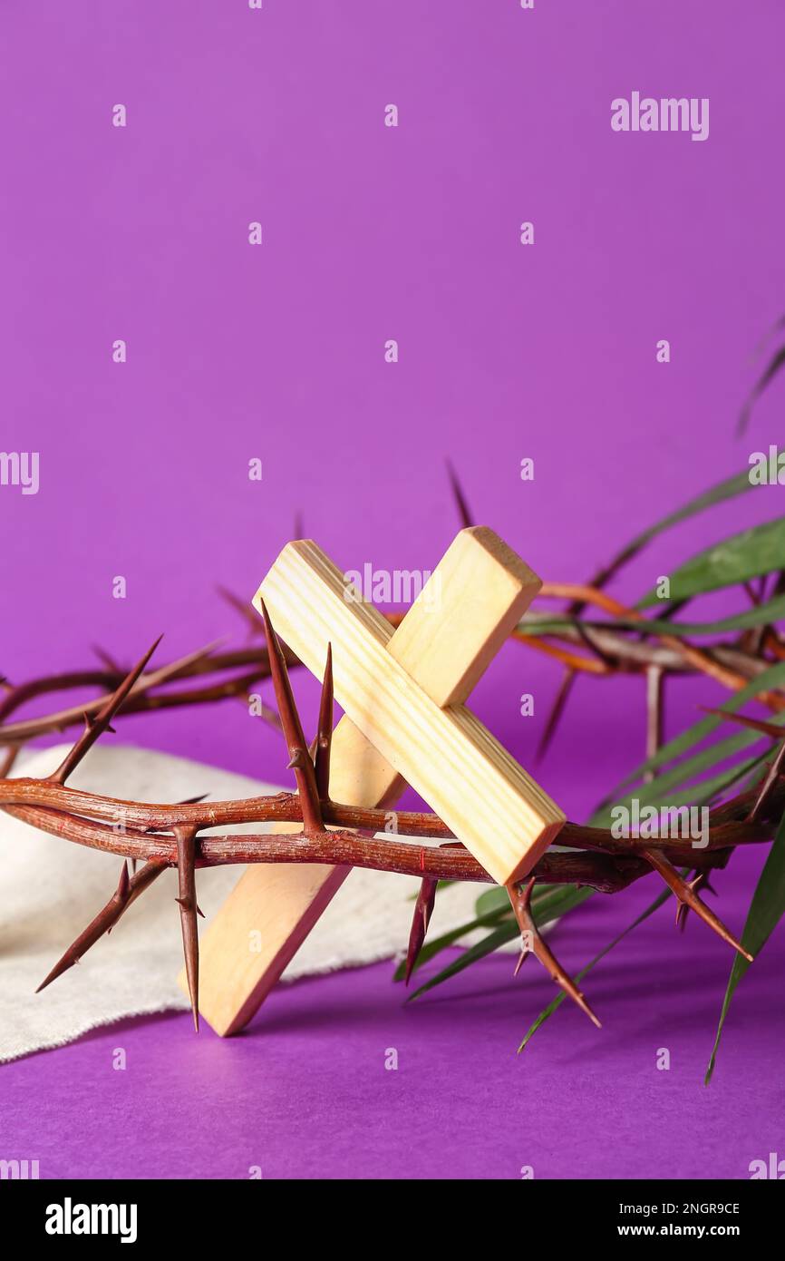 Crown of thorns with wooden cross and shroud on violet background ...