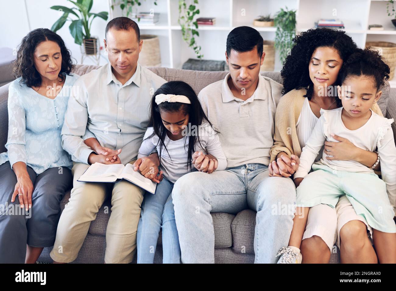 Religious, religion and family praying together in a home or house and ...
