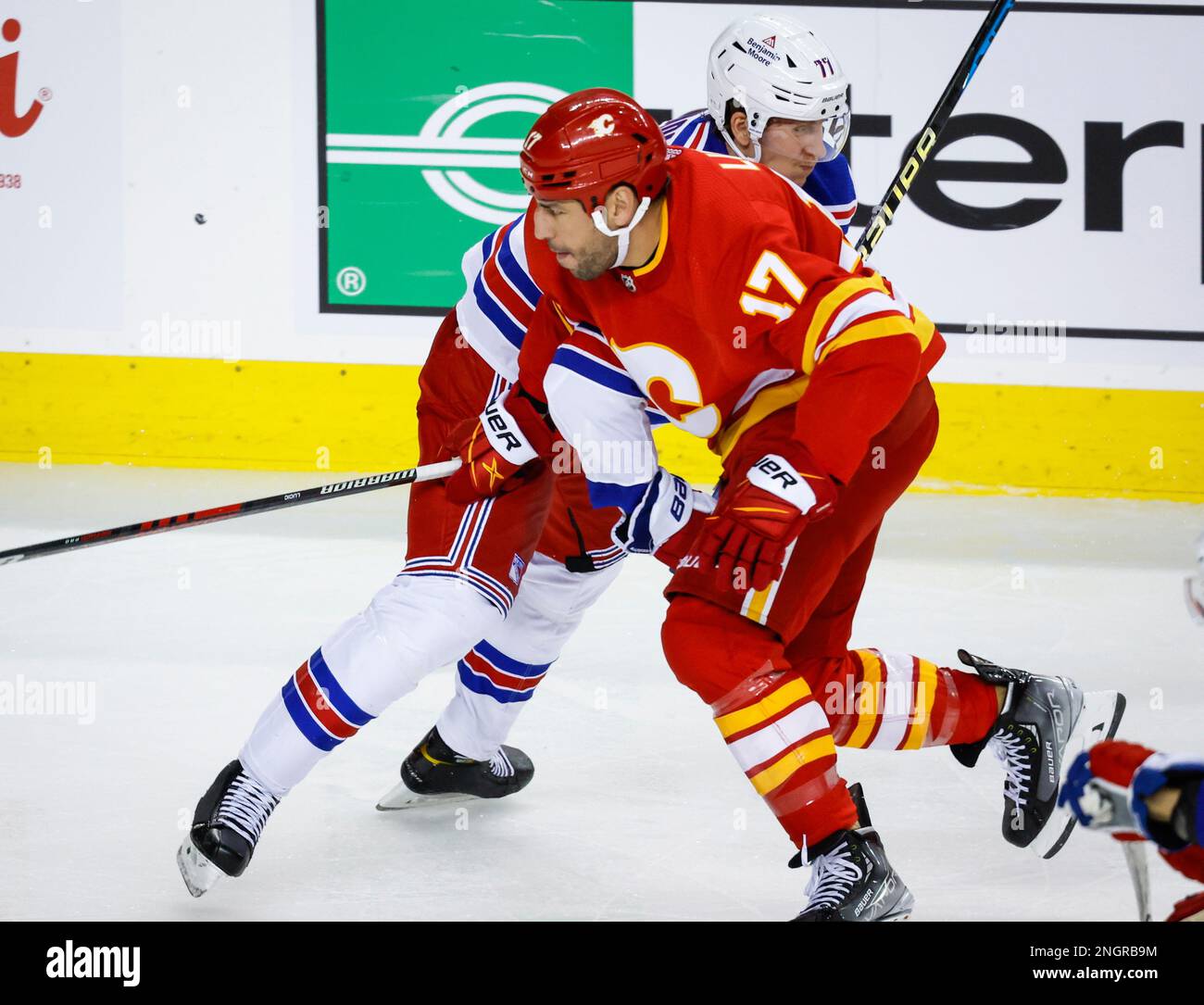 New York Rangers defenseman Niko Mikkola, left, checks Calgary Flames ...
