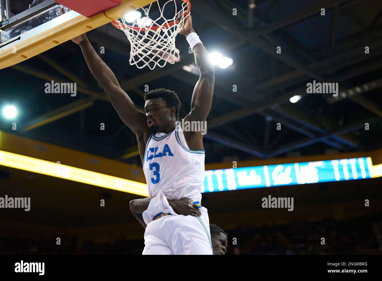UCLA forward Adem Bona (3) hangs from the rim after a dunk, as a ...