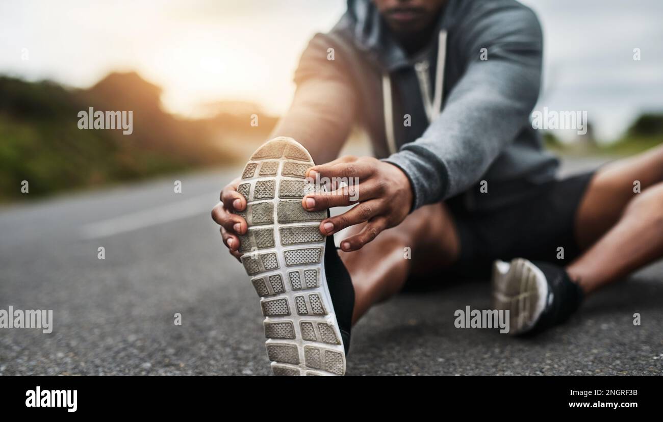 Stretching out those hamstrings. a handsome young sportsman warming up ...
