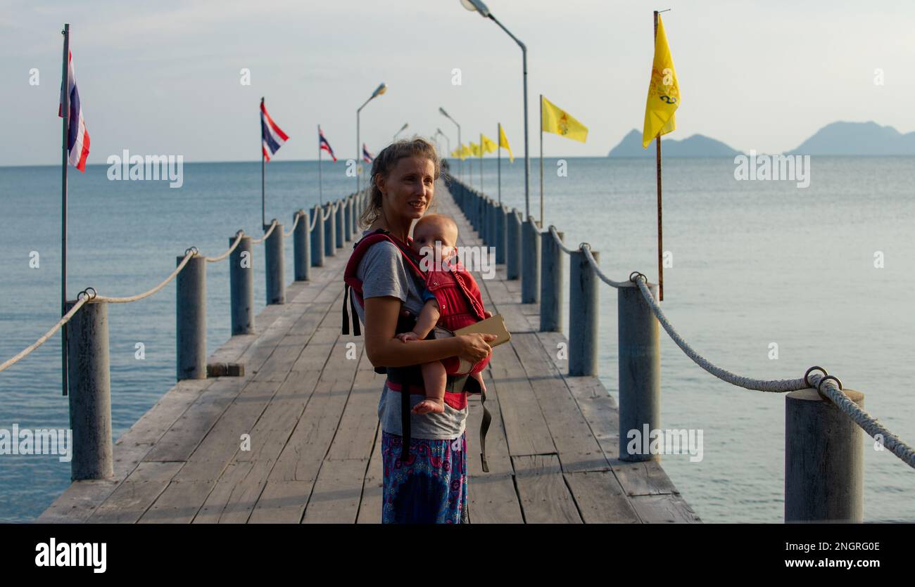 Tourist with baby strapped to chest on pontoon waiting for ferry Stock ...