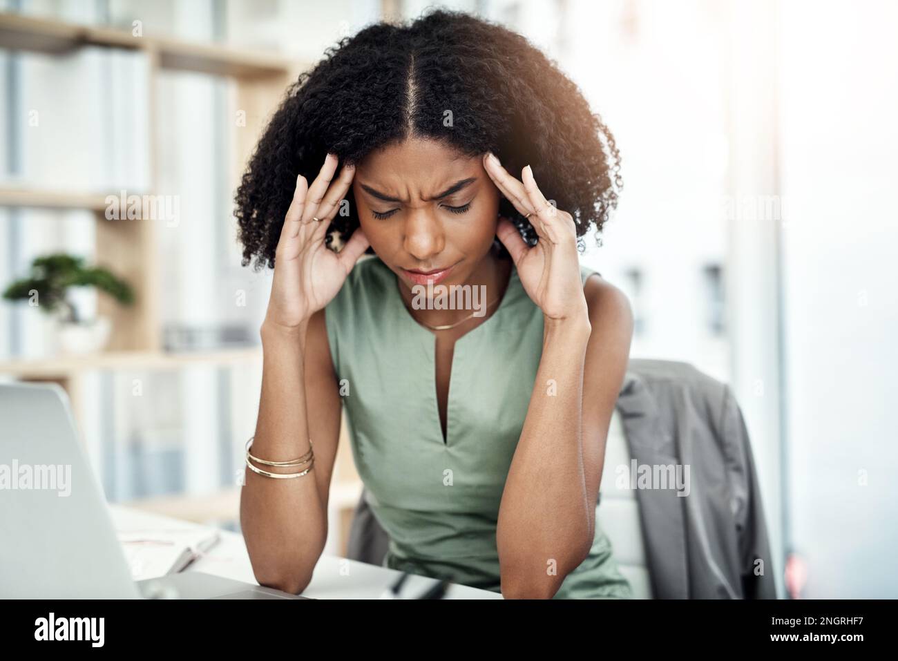 Headaches really bring down productivity. an attractive young ...