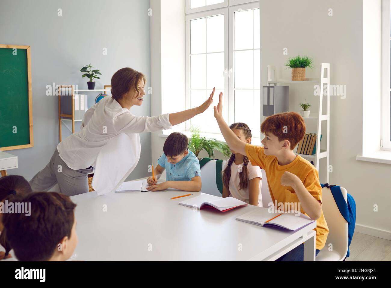 Teacher and student give high fives to each other after successfully ...
