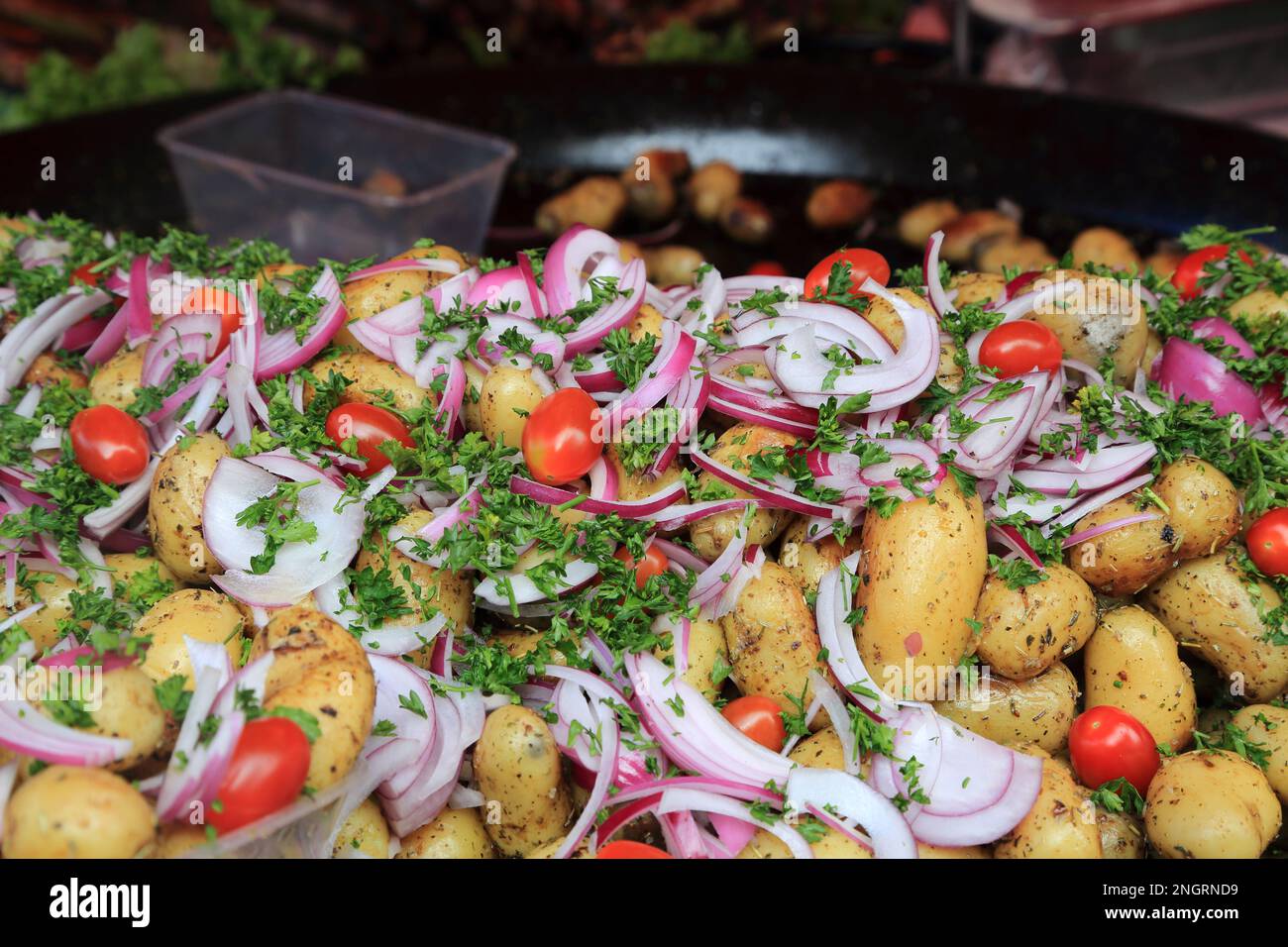 Potato dish being cooked on a market stall in market at Place des Lices ...